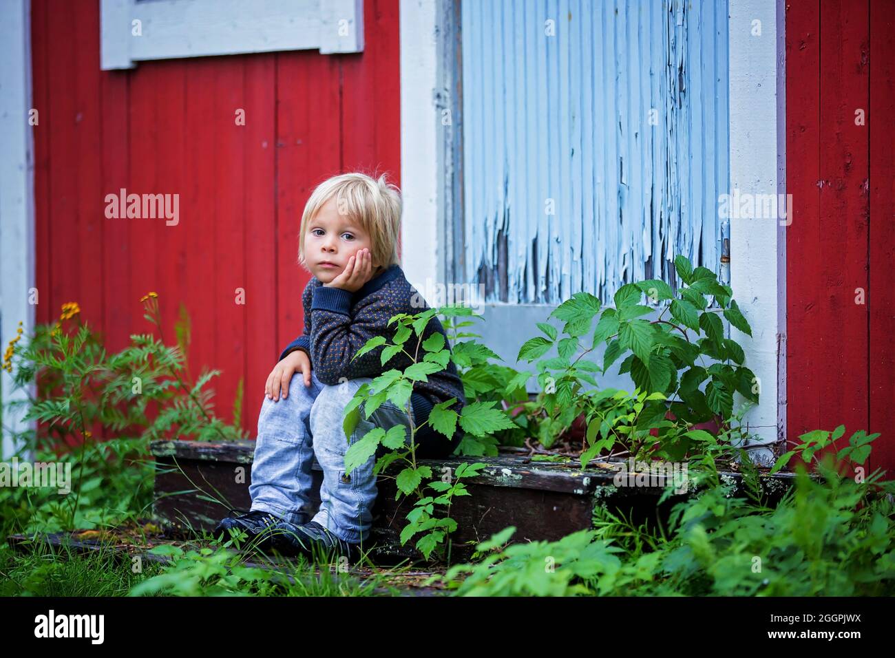 Sad little child, preschool boy, sitting on stairs in front of old ...