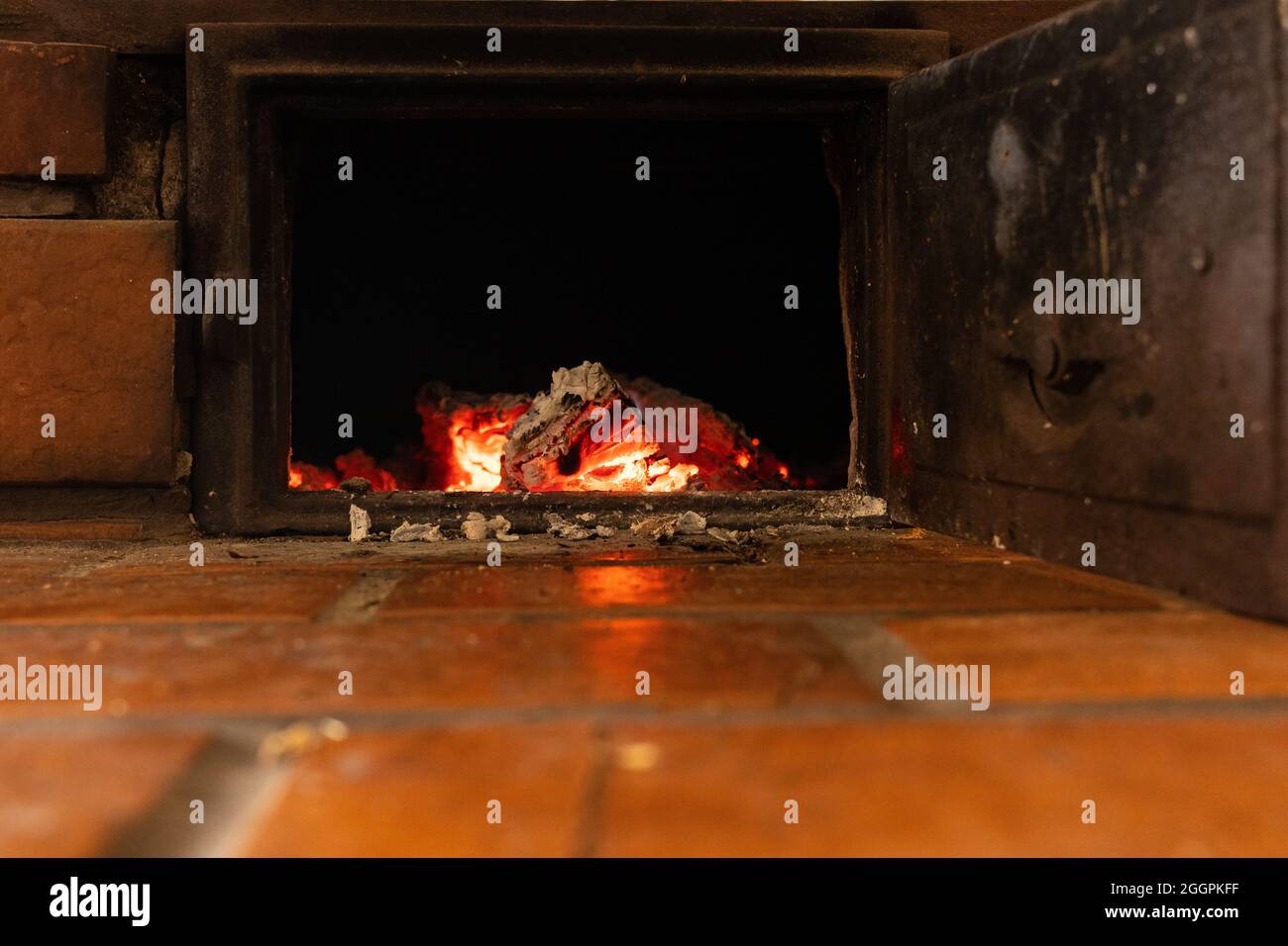Firewood stove with bricks, highlighting the ember. Black orange color ...