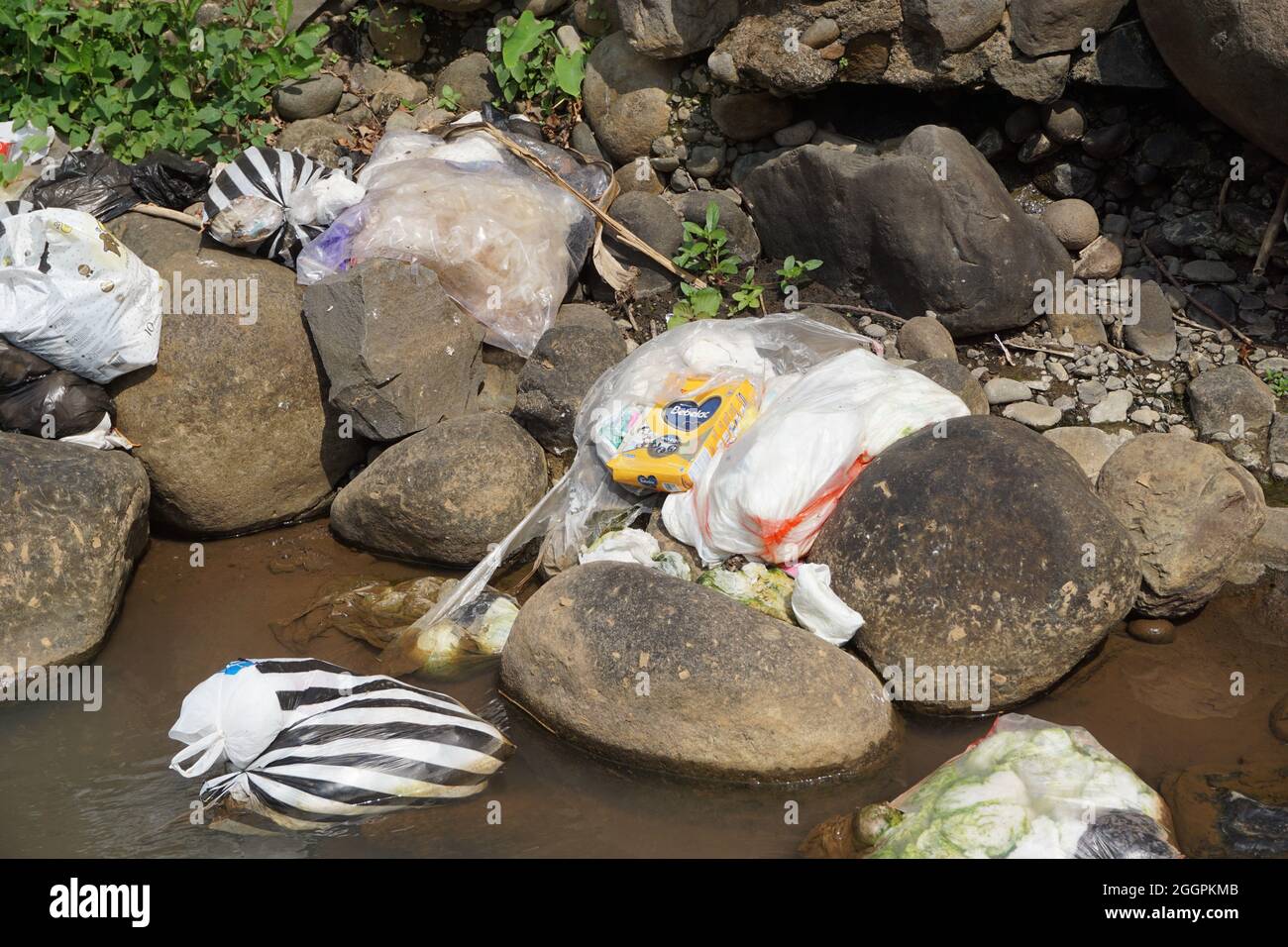 The garbage in the river with rock background Stock Photo - Alamy
