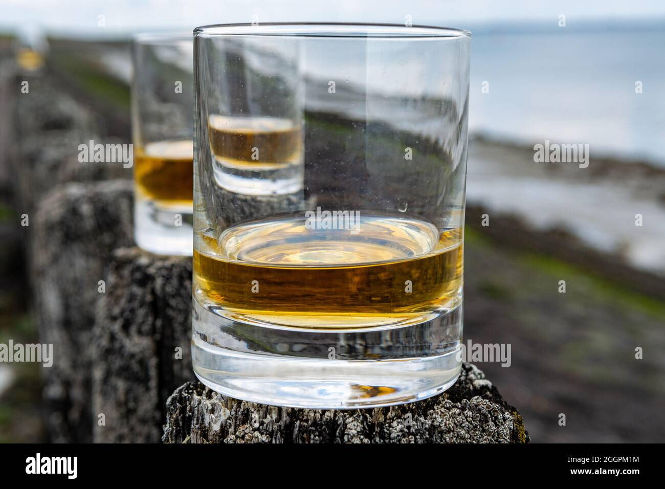 Tasting of dram single malt scotch whisky on seashore in Scotland, old ...