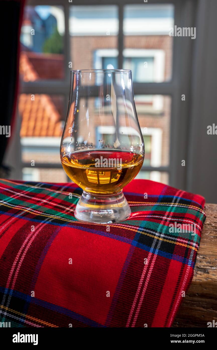 Dram of single malt scotch whisky served in tasting glass with view on ...