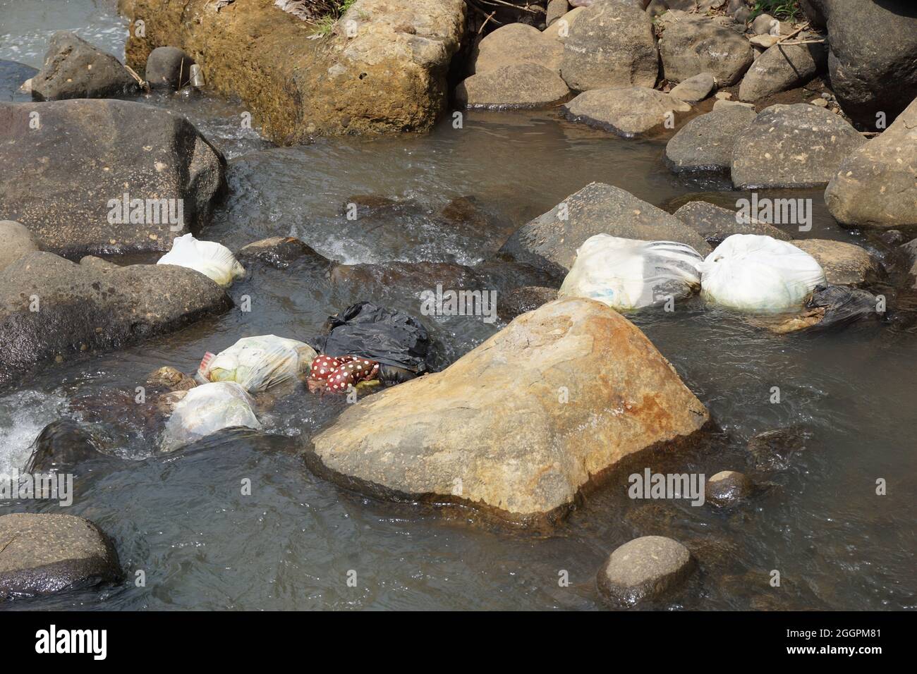 The garbage in the river with rock background Stock Photo - Alamy