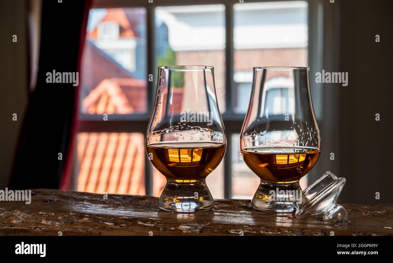 Dram of single malt scotch whisky served in tasting glass with view on ...