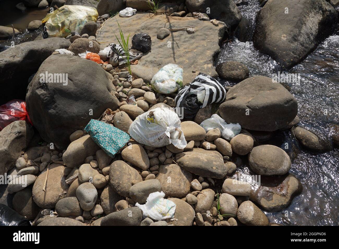 The garbage in the river with rock background Stock Photo - Alamy