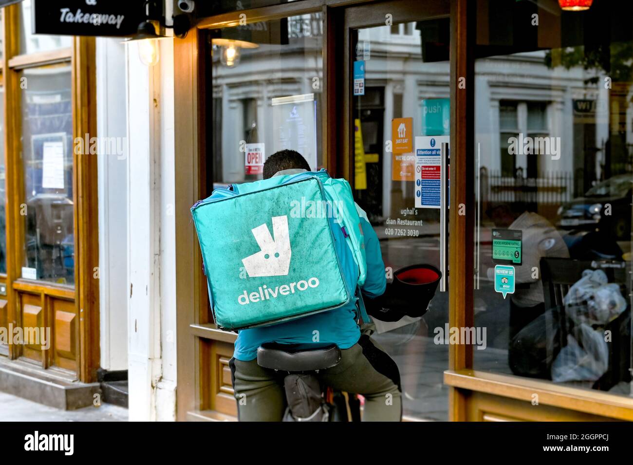 London, England - August 2021: Person working for Deliveroo waiting ...