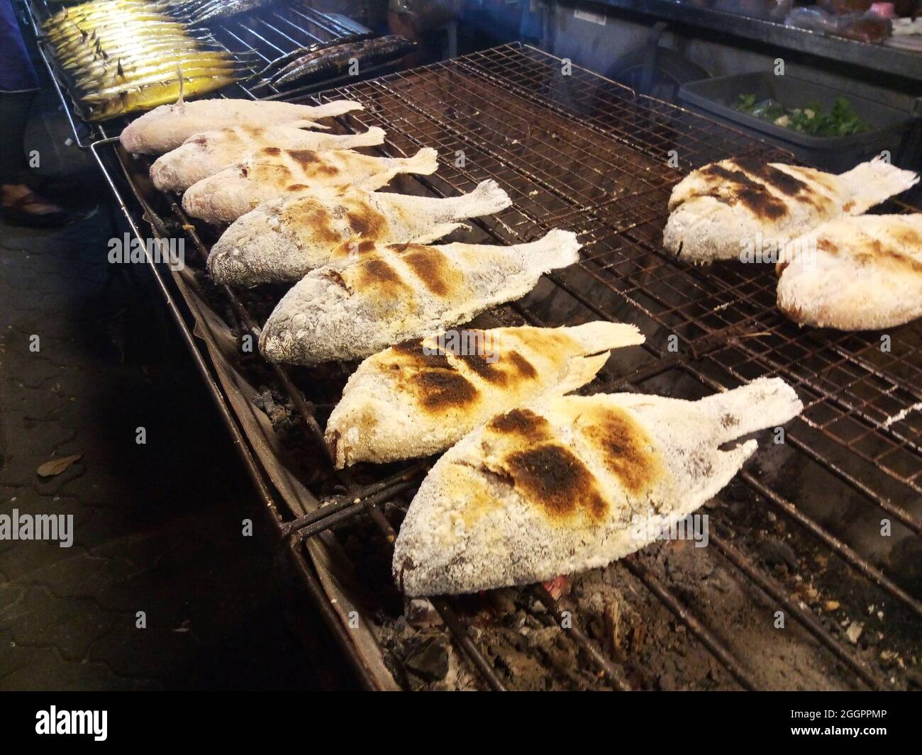 Fresh fish is grilled at the fish market Stock Photo - Alamy