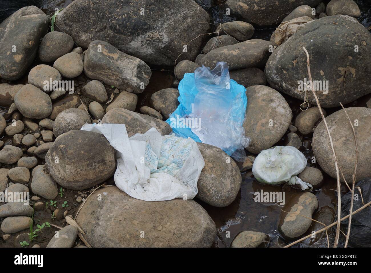 The garbage in the river with rock background Stock Photo - Alamy