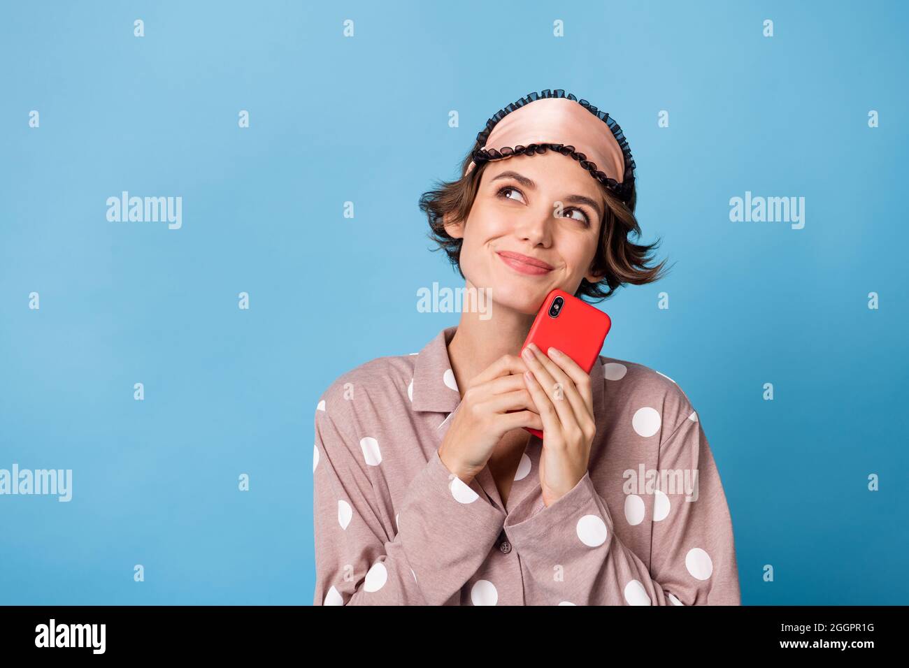 Photo of dreamy young woman hold phone imagine comment look empty space ...