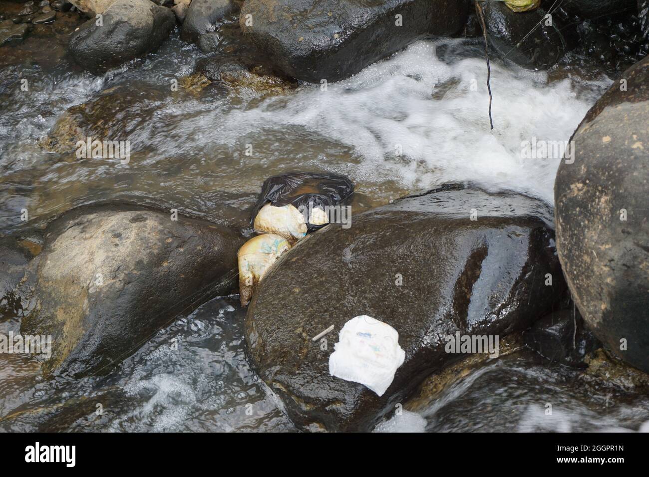 The garbage in the river with rock background Stock Photo - Alamy