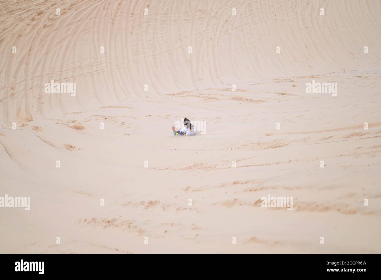 Couple in love slide down from the sand dunes. Sunny day. Summer ...