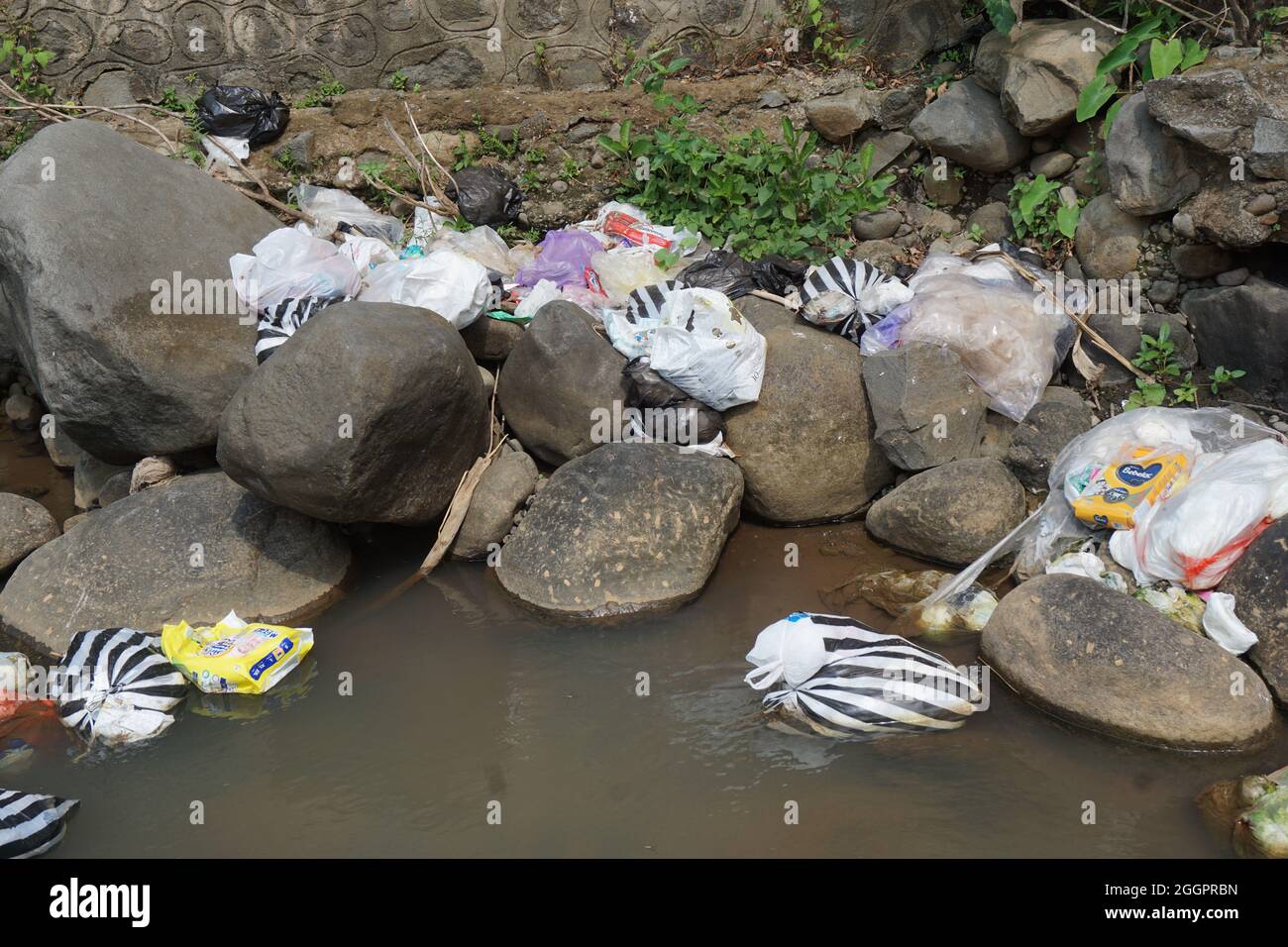 The garbage in the river with rock background Stock Photo - Alamy