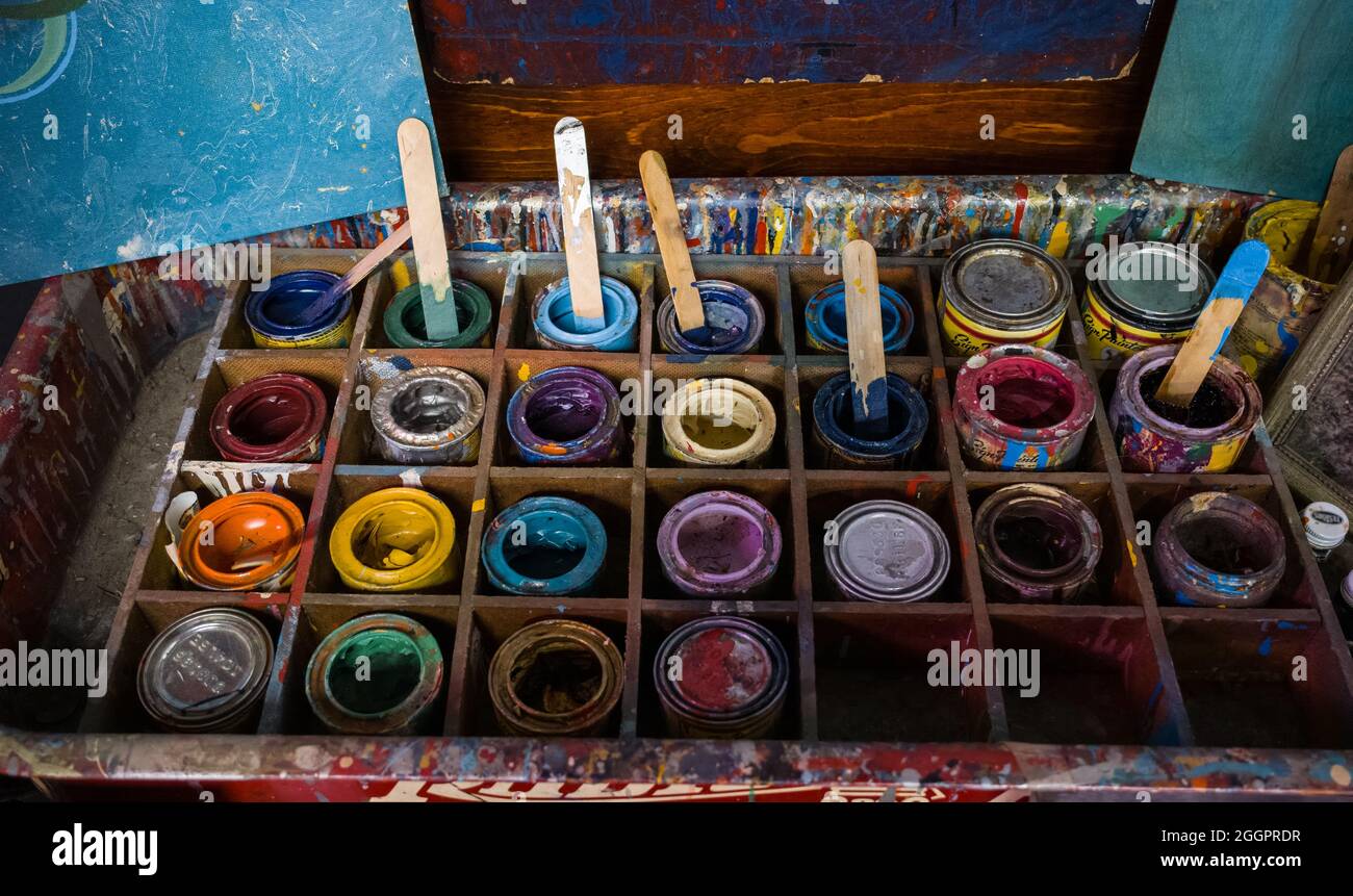 Top view of opened cans of dried up used colorful paints a few with ...
