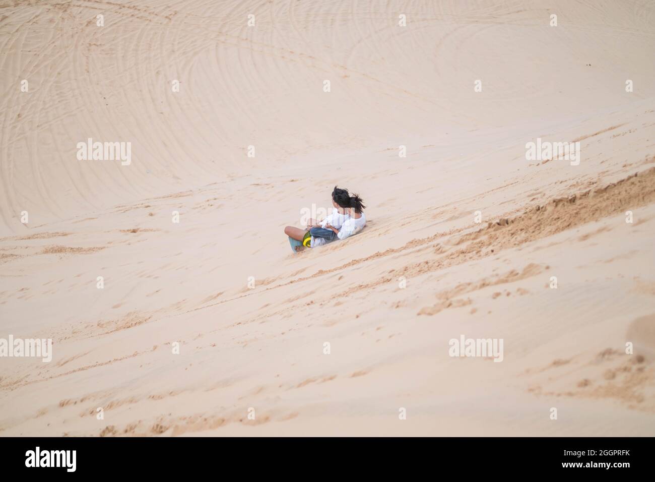 Lovely couple slide down from the sand dunes. Sunny day. Summer ...
