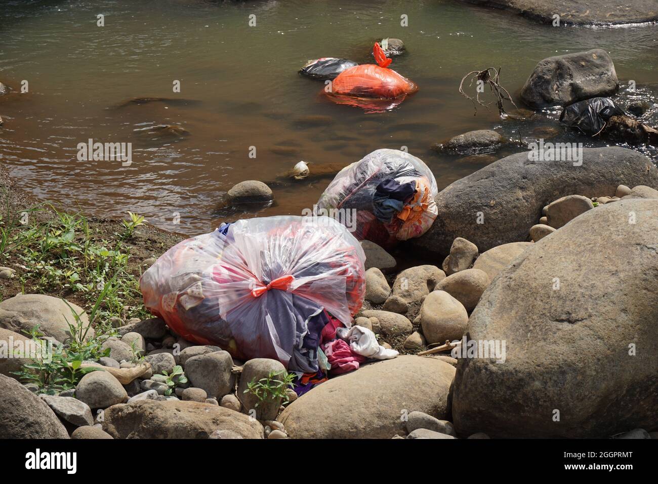 The garbage in the river with rock background Stock Photo - Alamy