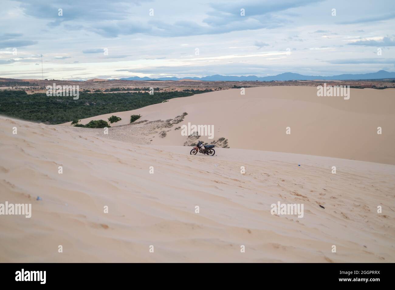Amazing view of parked motorbike on sandy dunes in desert. Sunny day ...