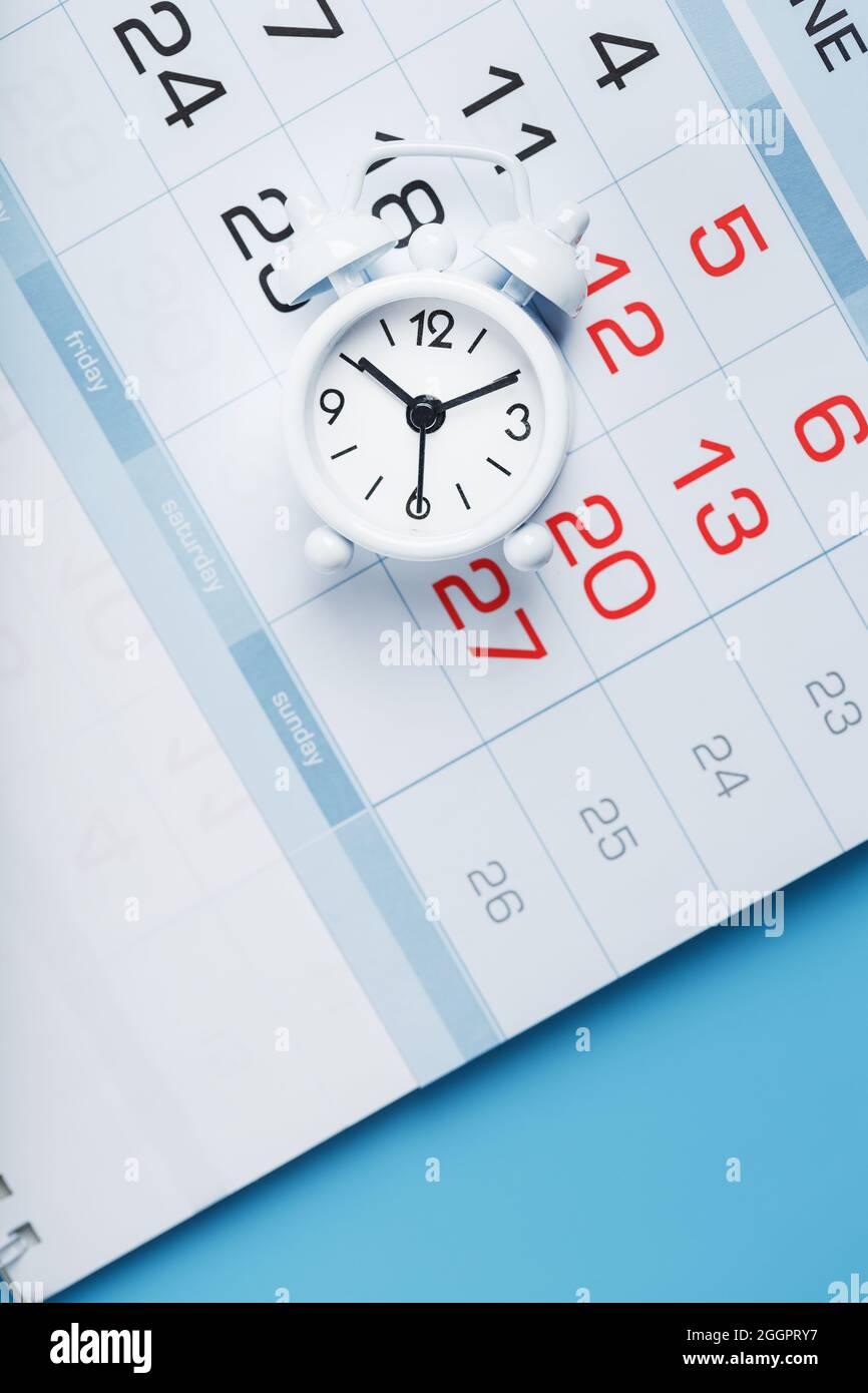 Annual calendar with a white alarm clock on a blue background. The ...