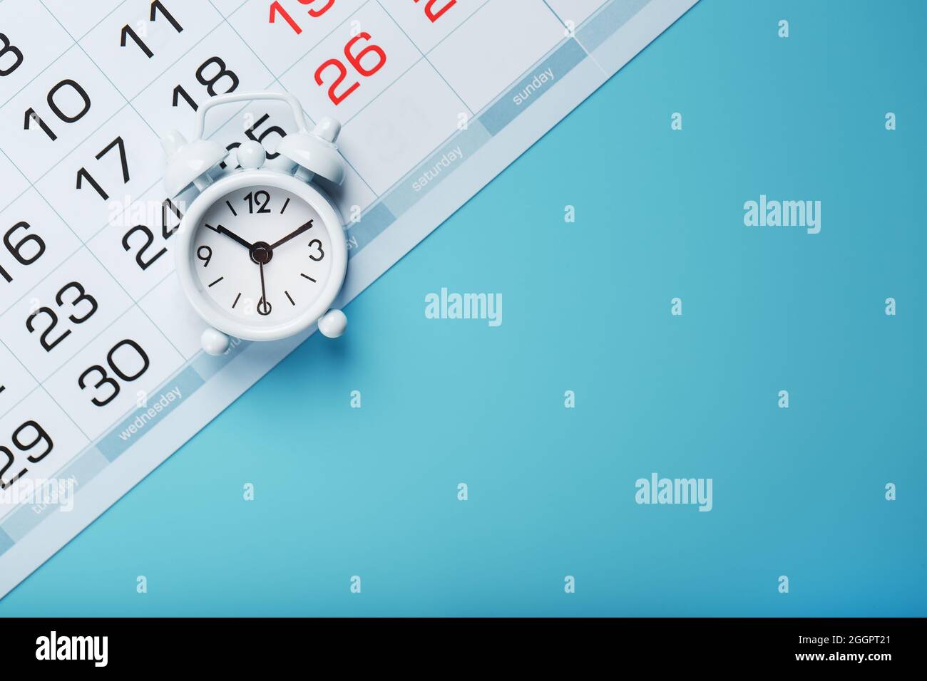 Annual calendar with a white alarm clock on a blue background. The ...