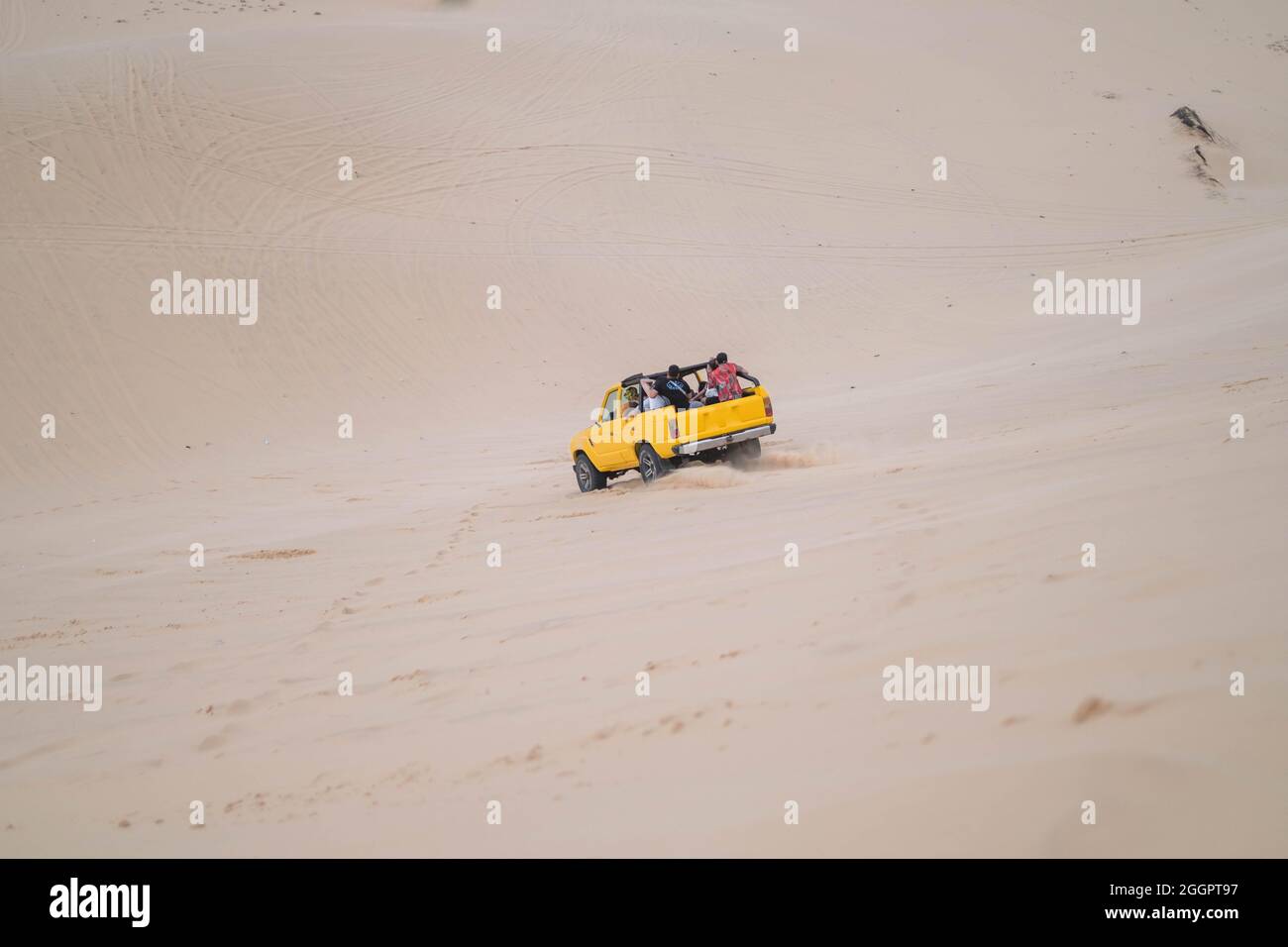 Picturesque view of big car driving on sandy dunes and tire tracks on ...