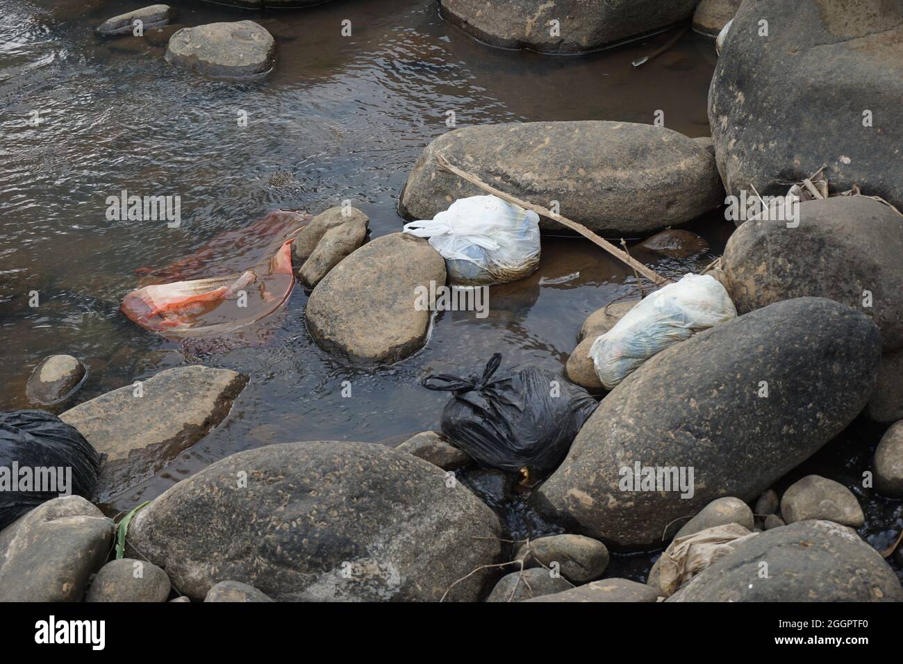The garbage in the river with rock background Stock Photo - Alamy