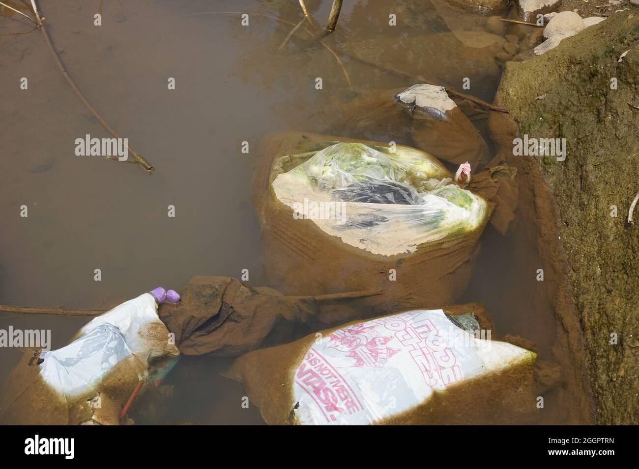The garbage in the river with rock background Stock Photo - Alamy