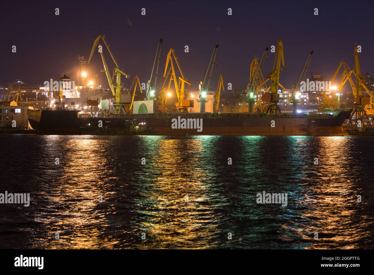 Vessel dry cargo on loading, unloading in port at night time. Bulker in ...