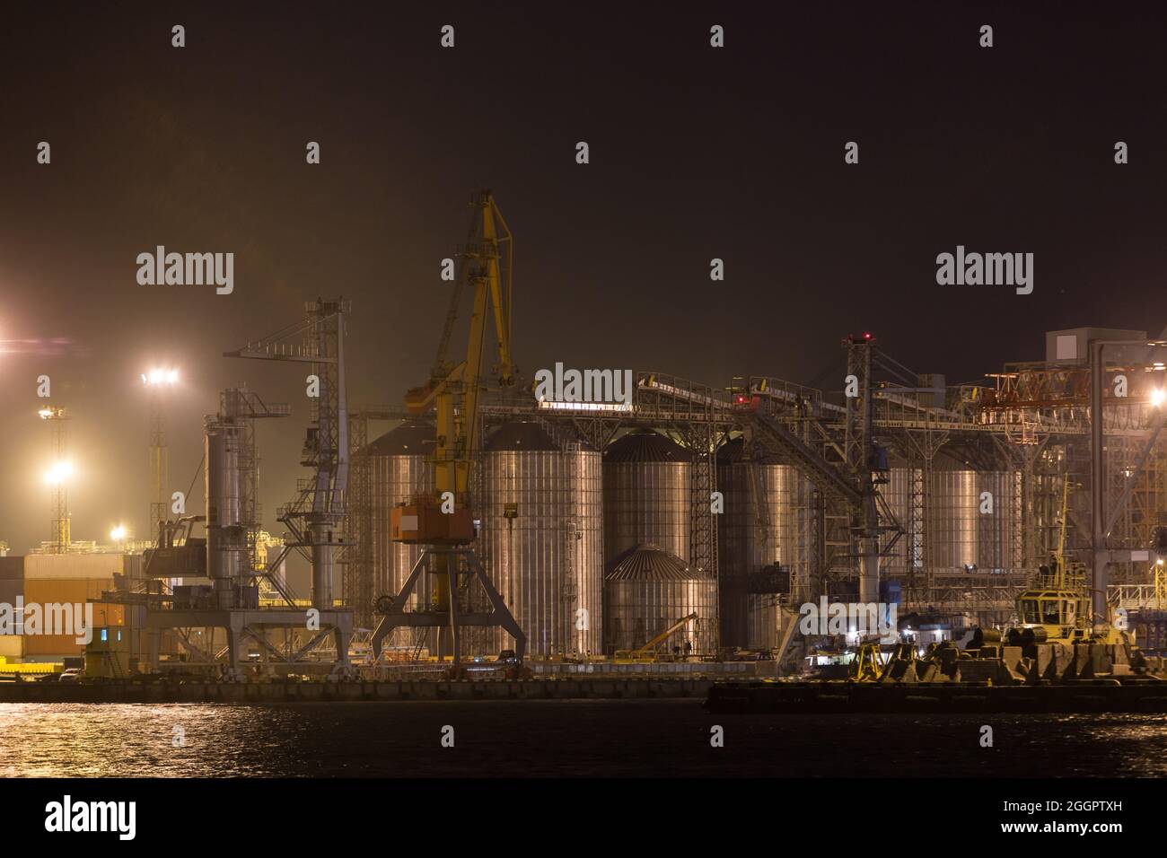 Port grain elevator in night time. Industrial sea trading port bulk ...