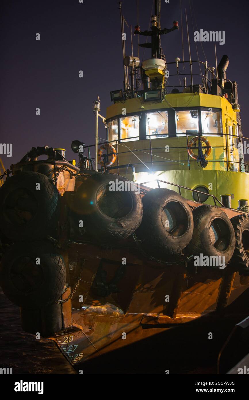 tug ship support at port in night time. close-up tug ship in night ...