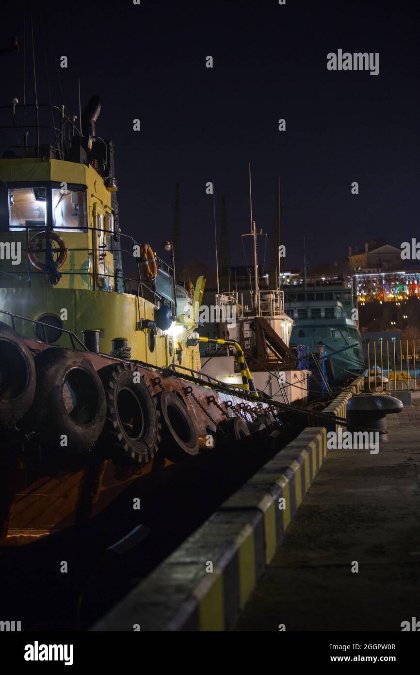 tug ship support at port in night time. close-up tug ship in night ...
