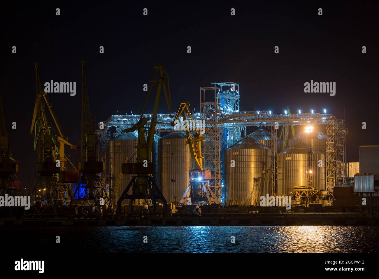 Port grain elevator in night time. Industrial sea trading port bulk ...