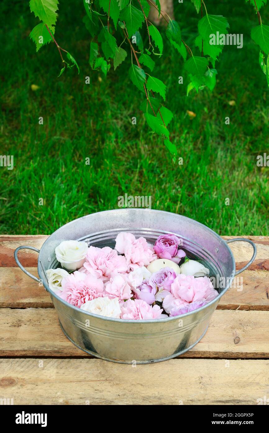 Garden party decorations: silver bucket with floating flowers. Summer ...
