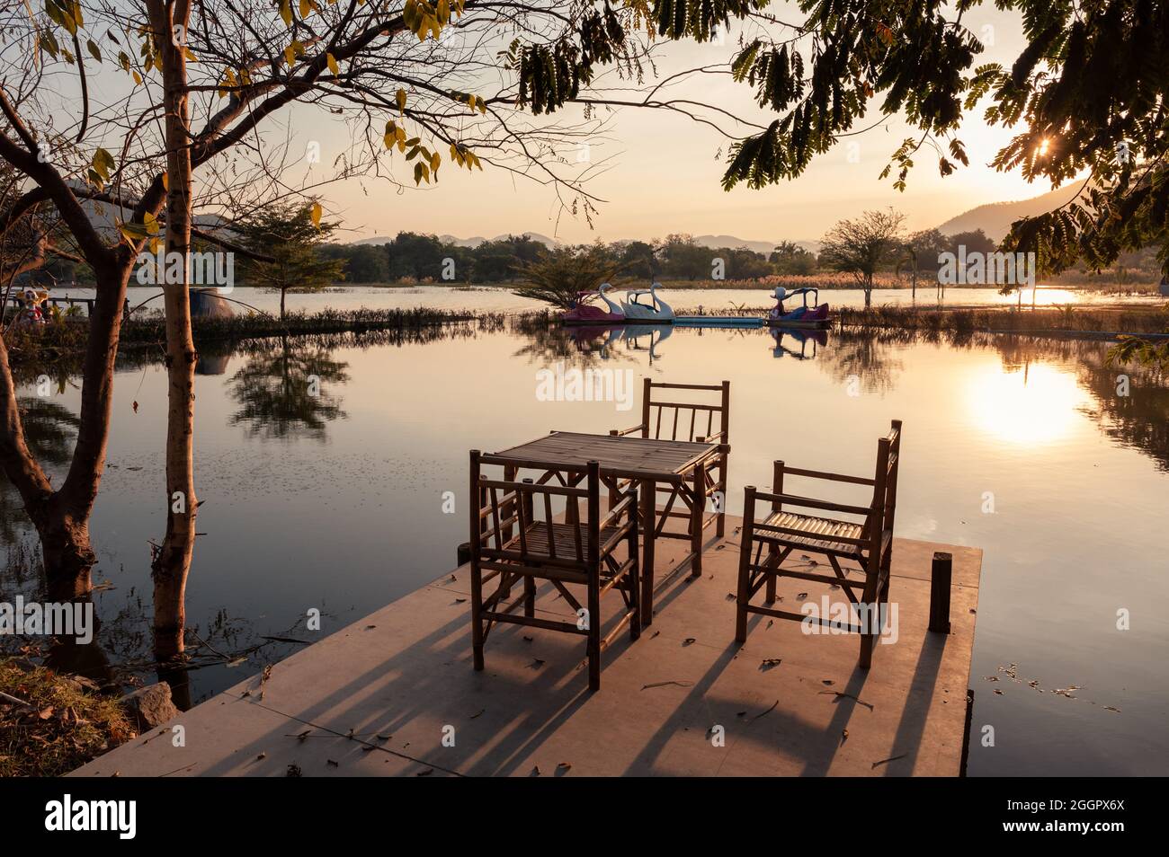 Weave bamboo table and chairs with lake view on waterfront at sunset ...