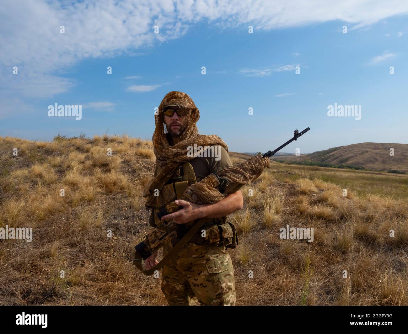 Sniper-mercenary in camouflage clothes under the scorching sun. He ...