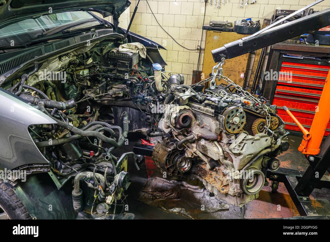 dismantling a damaged engine from a car with the help of a folding ...