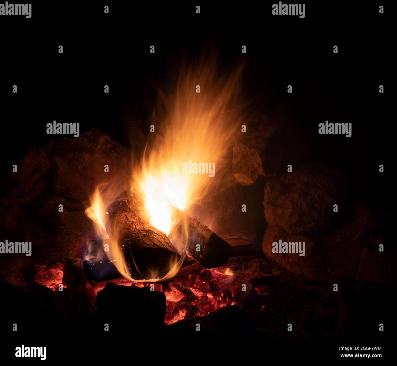 Campfire at night with flames rising above the rocks Stock Photo - Alamy