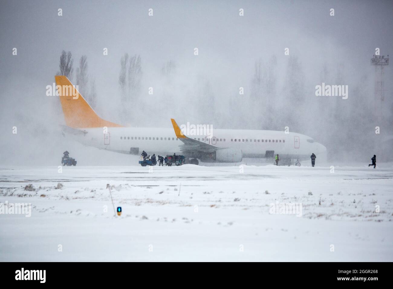 Airliner on runway in blizzard. Aircraft during taxiing on landing ...