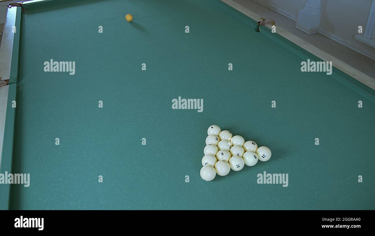 Player plays billiards breaks pyramid of balls, recreation concept ...