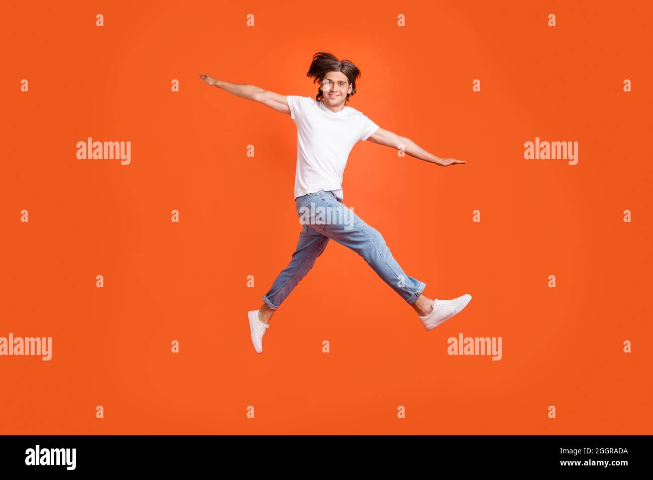 Full body photo of cheerful young happy positive man jump up hands ...