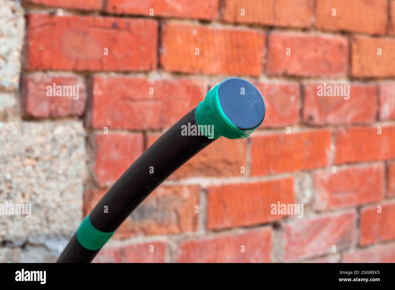 Water supply polyethylene pipe with a plug on the background of a brick ...