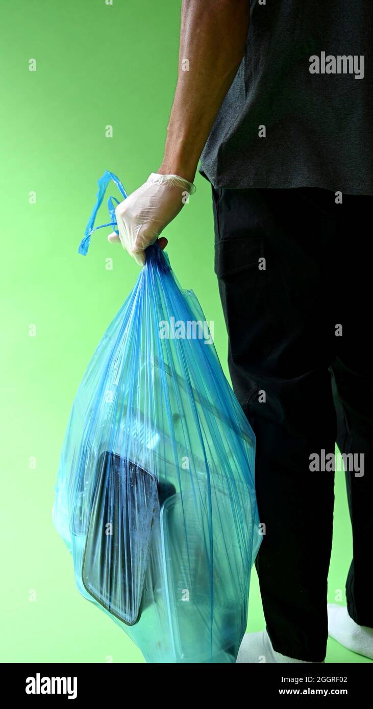 Hand holding black rubbish bag hi-res stock photography and images - Alamy