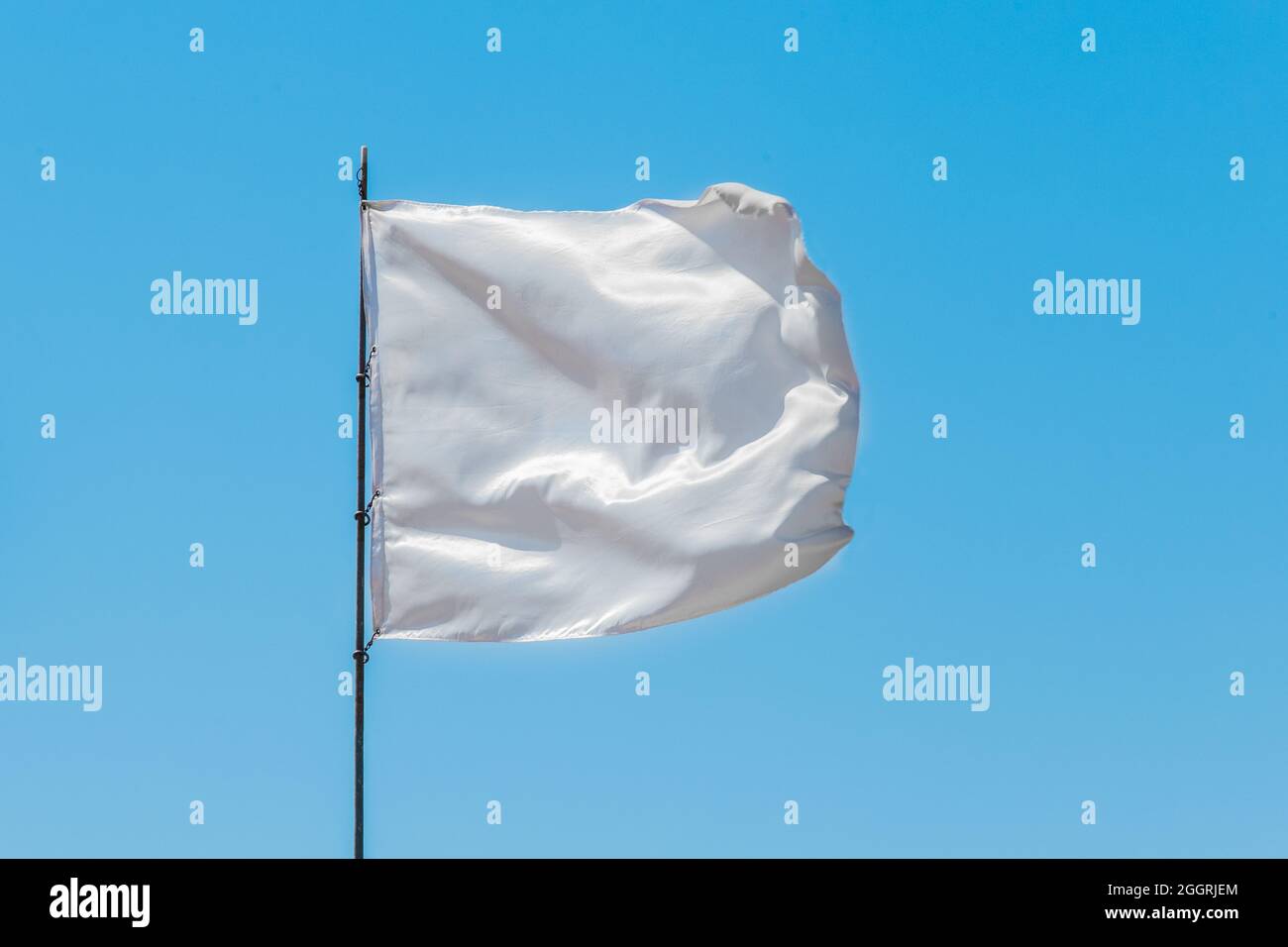 White flag sign and symbol of goodness and truce on blue sky background ...