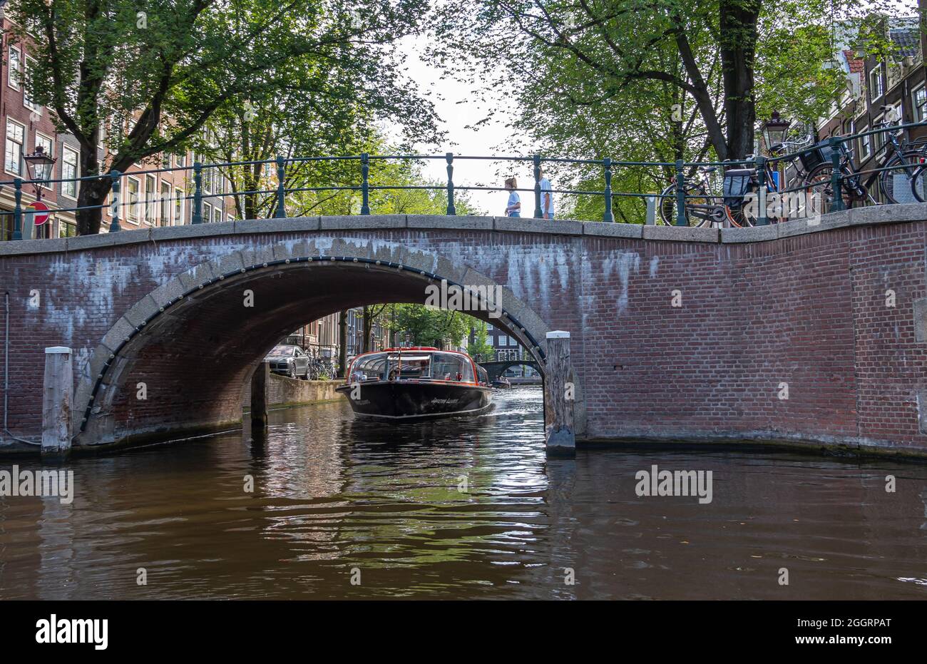 Amsterdam, Netherlands - August 15, 2021: Small low bridge on canals ...