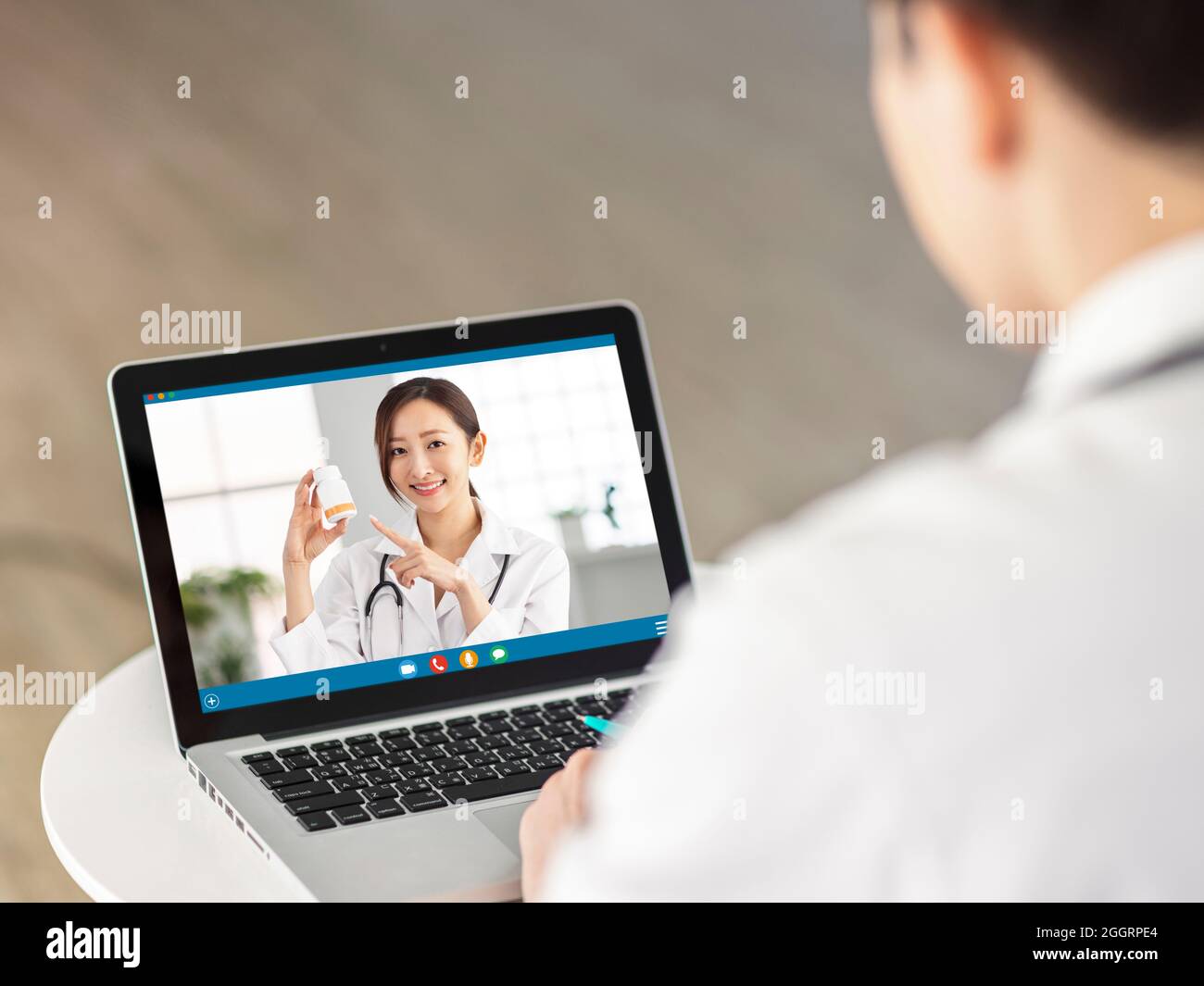 Back view of doctor making video call with his colleague.Smiling doctor ...