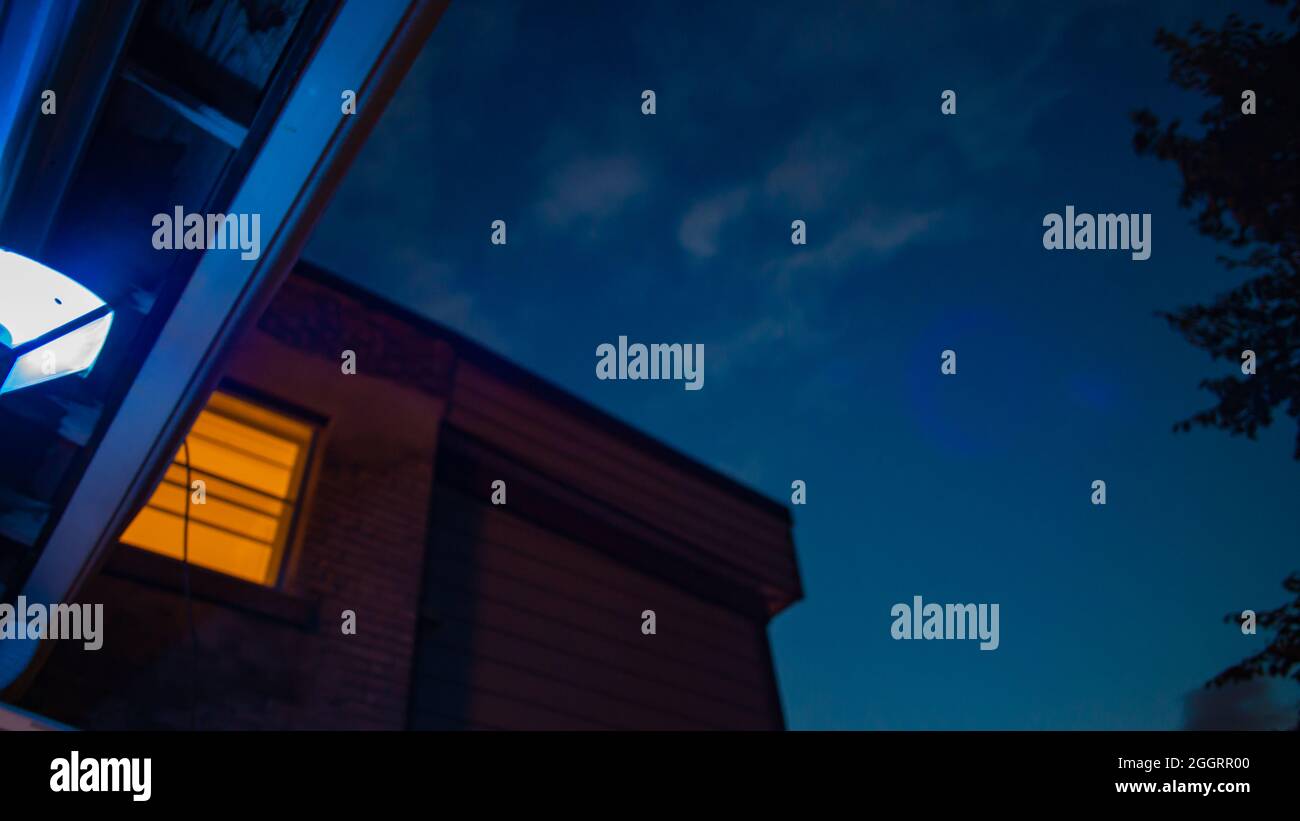 Orange city lights, windows, streets under blue and crimson sunset sky ...