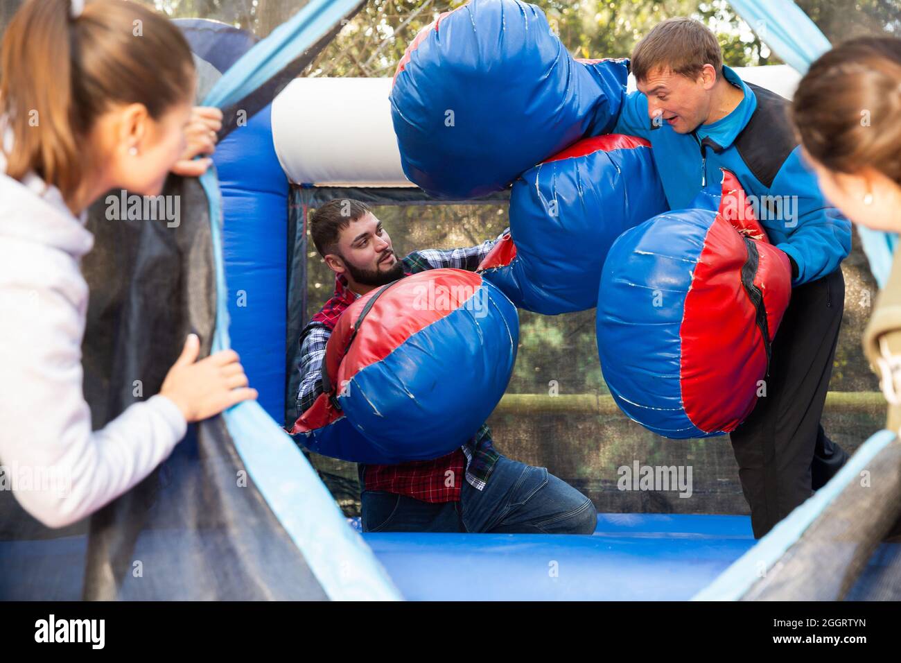 Male friends fighting at amusement playground Stock Photo - Alamy