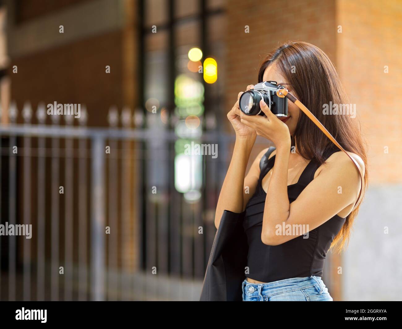 Female freelancer photographer taking picture with film camera, young ...