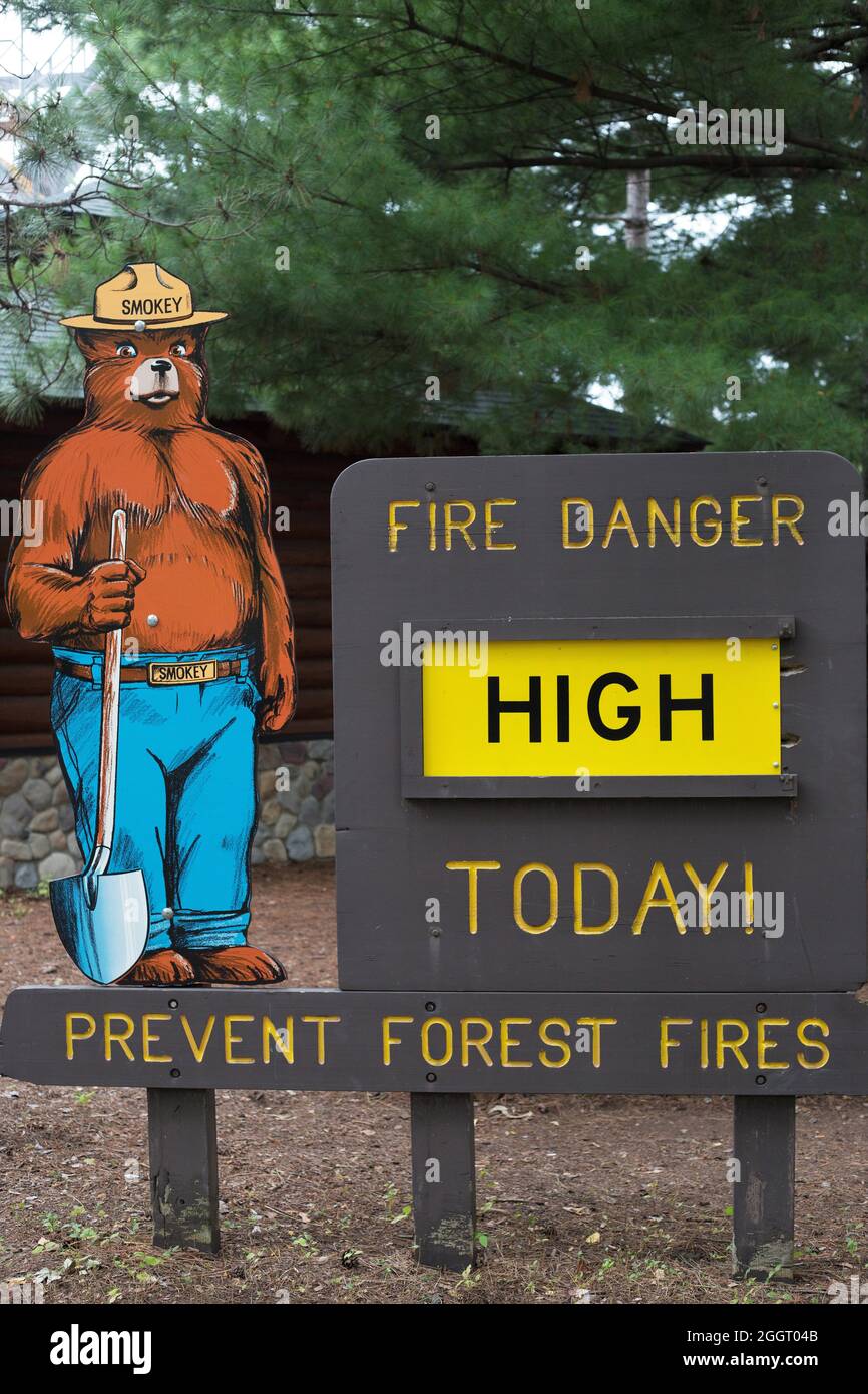 A sign stating "high fire danger" next to an image of Smokey the Bear ...
