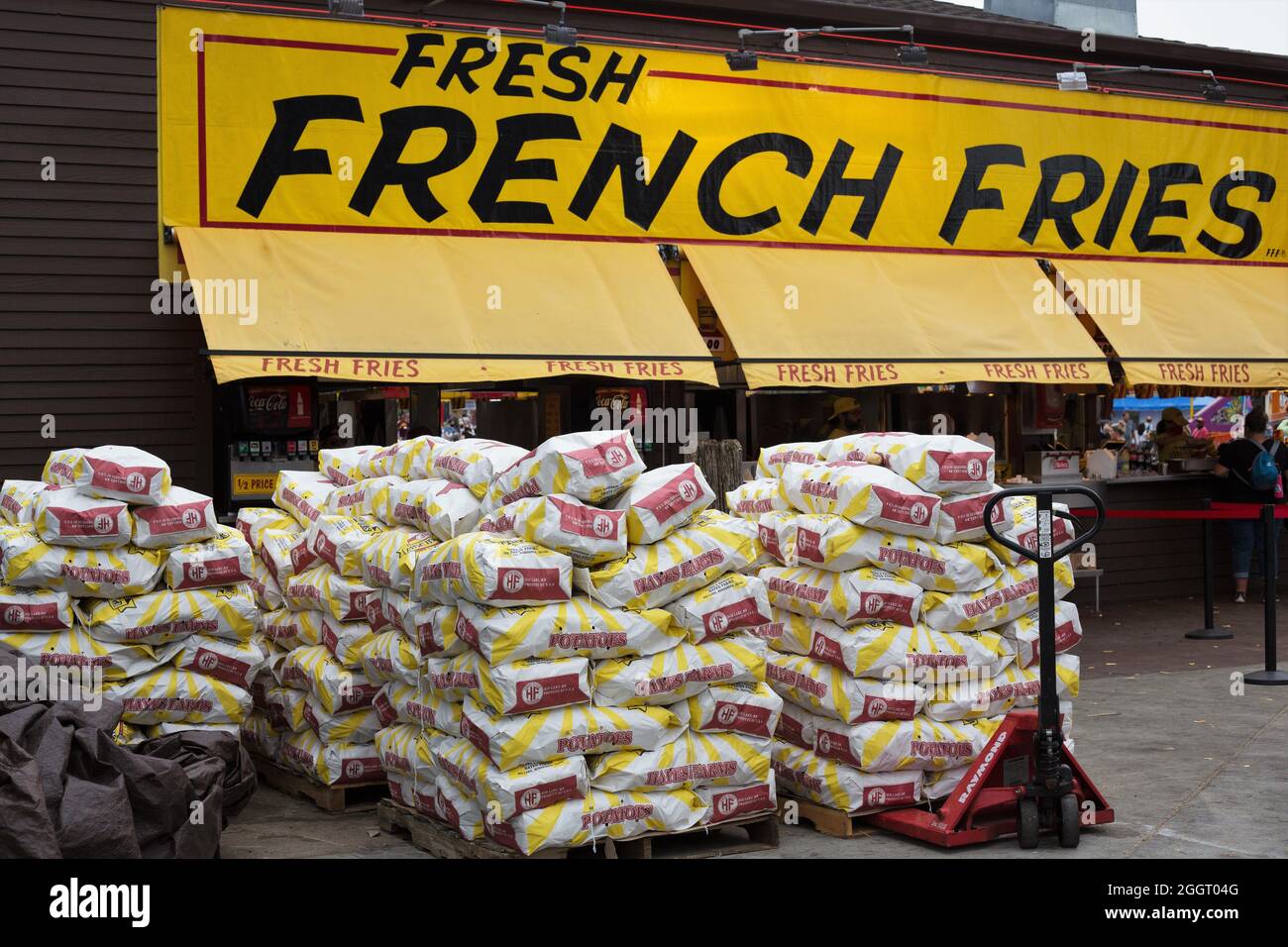 Large piles of bags of potatoes next to a French Fries booth at the ...