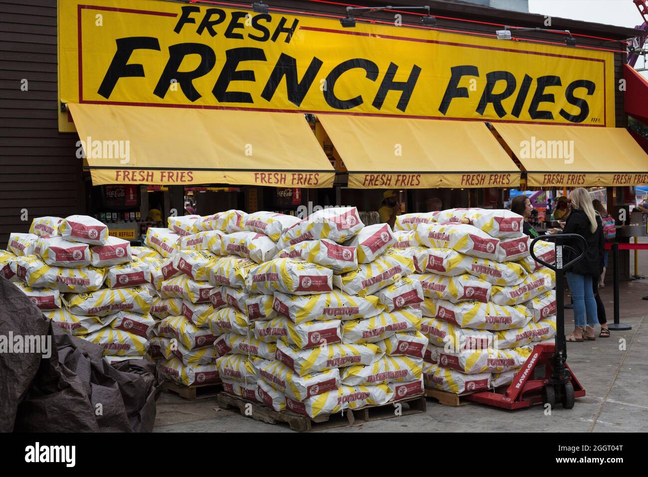 Large piles of bags of potatoes next to a French Fries booth at the ...