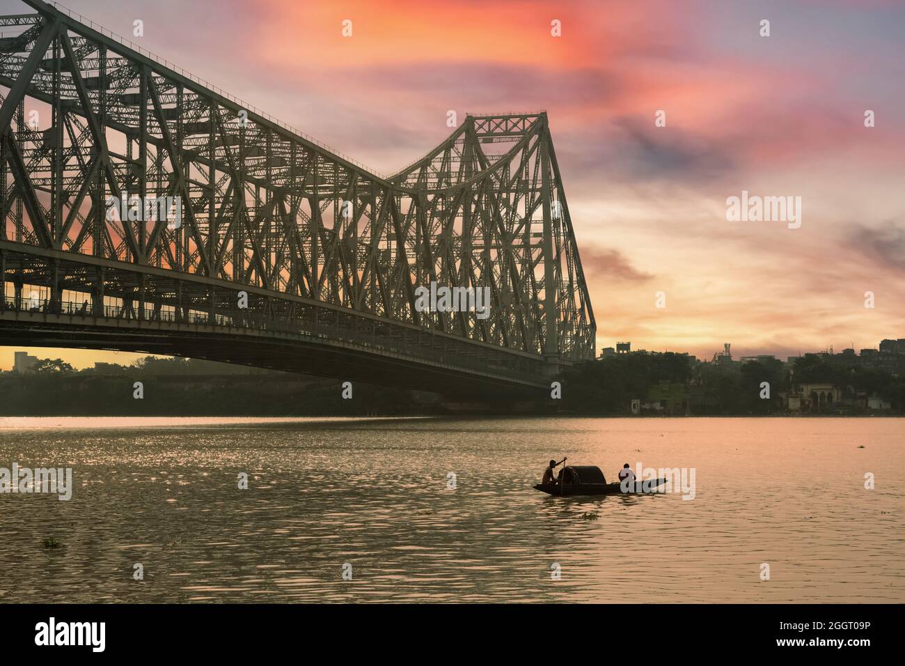 Howrah bridge at sunset with view of a fishing boat on river Ganges and ...