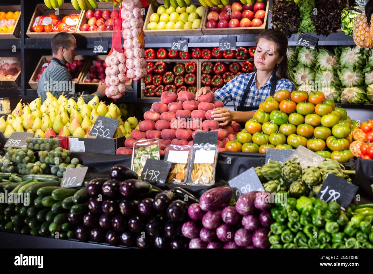 Posing glad woman and working man in fruit shop Stock Photo - Alamy